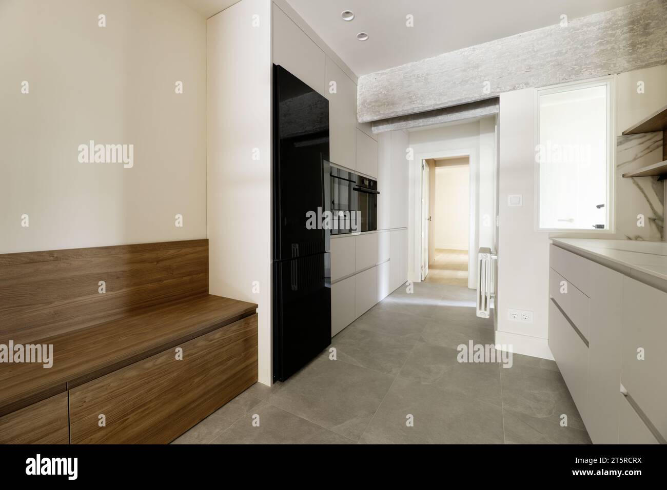 Newly installed narrow kitchen with white handleless furniture on one ...