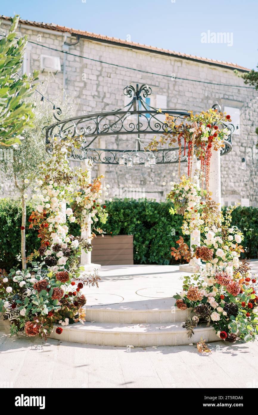 Wedding rotunda with columns decorated with flowers in the garden near ...