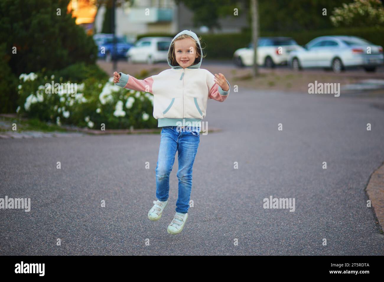 Adorable preschooler girl playing in park on a summer day. Happy child ...
