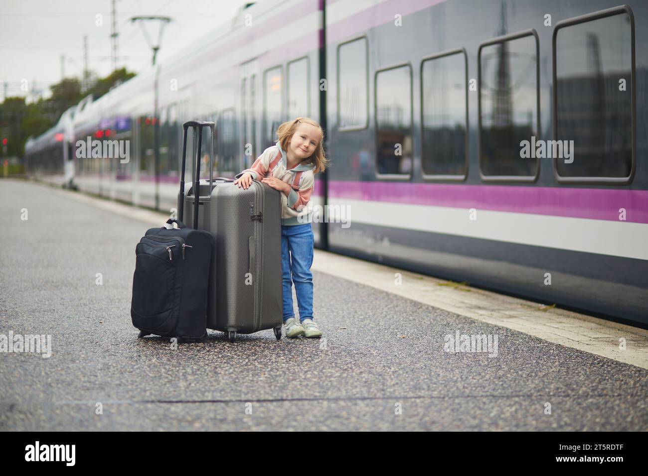 Adorable preschooler girl on a railway station. Little child waiting ...
