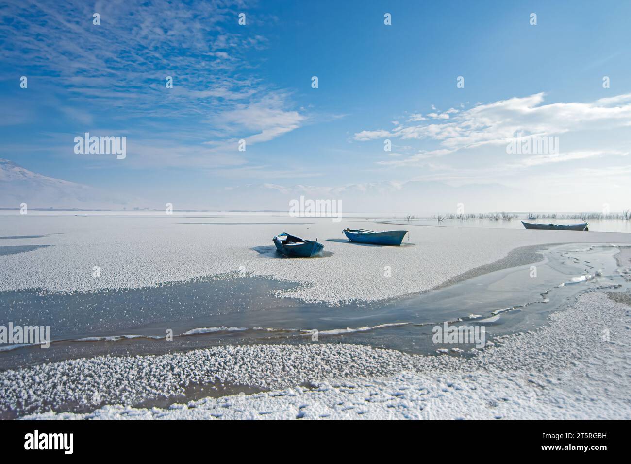 Boats on the frozen lake, blue sky and clouds Stock Photo - Alamy