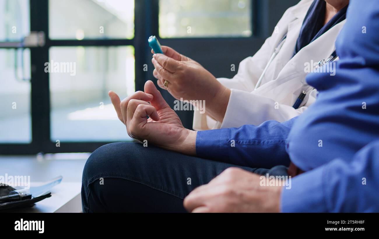 Old patient doing diabetes rutine control with glucometer instrument ...