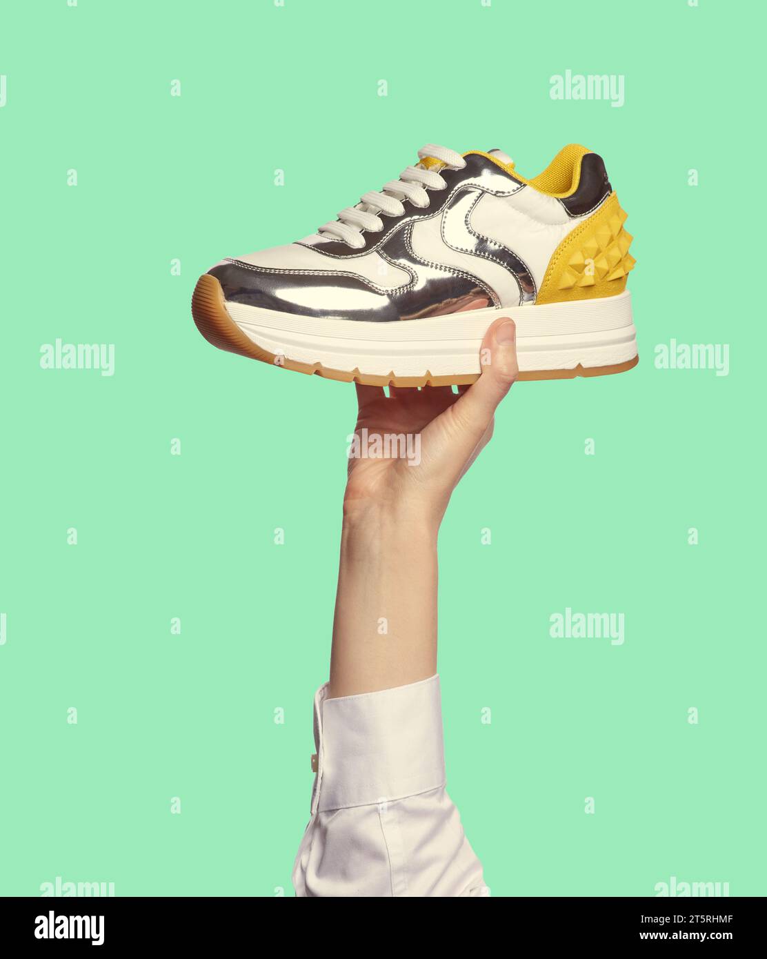 A woman's hand, wearing a white shirt, holding a fancy multicolor ...