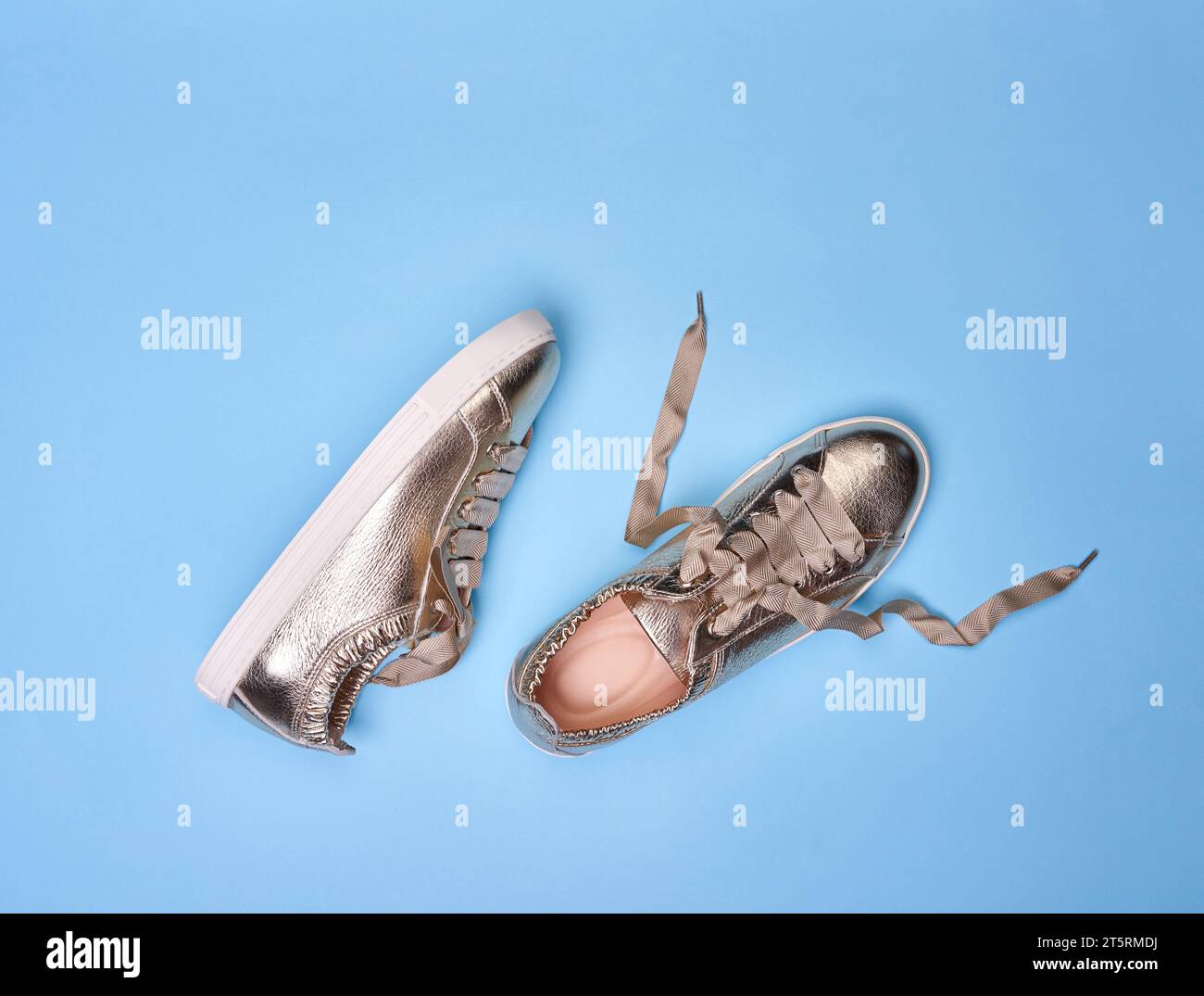 Stylish golden metallic sneakers with wrinkled leather details and ...