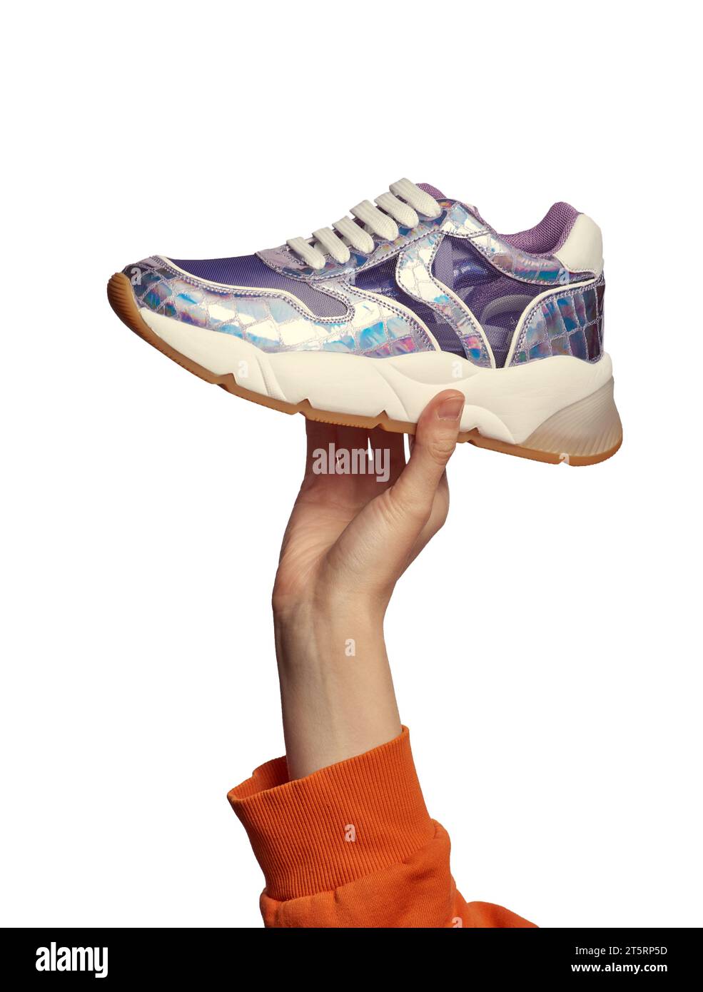 A man's hand holding a stylish sneaker with a chunky insole and shiny ...