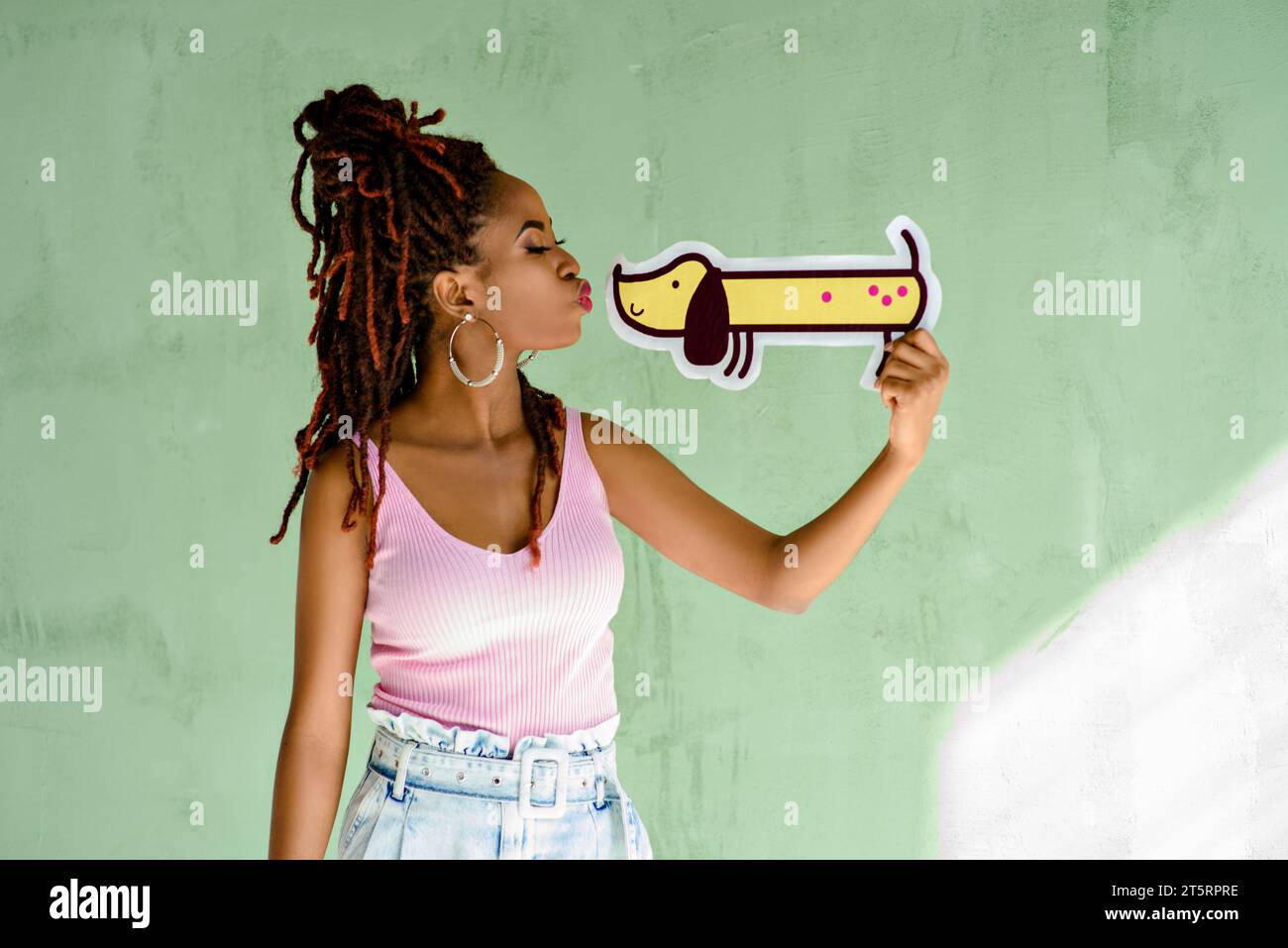 Beautiful young black woman is looking at the funny printed dog picture ...