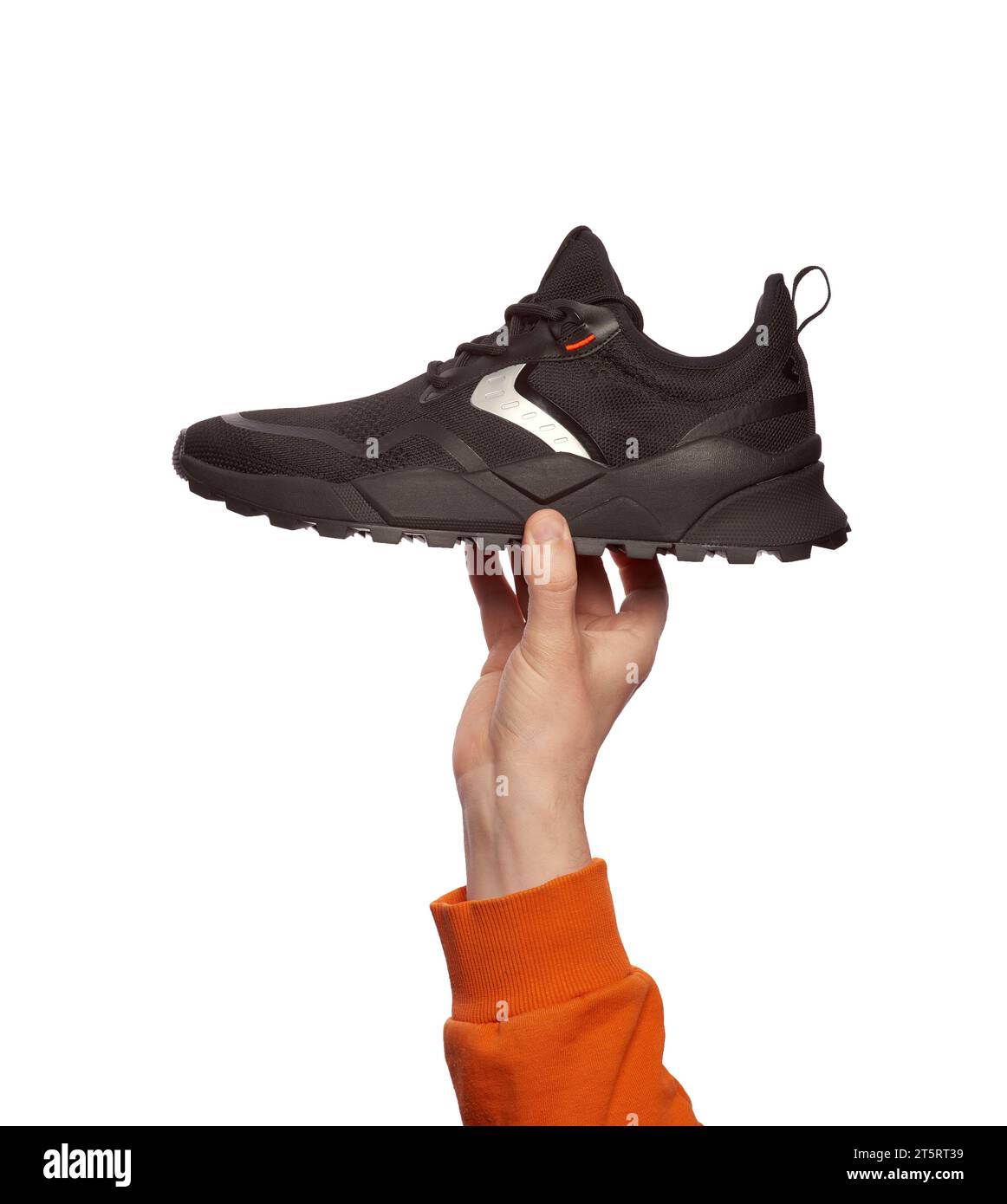 A man's hand holding a trendy black sneaker isolated on a white ...
