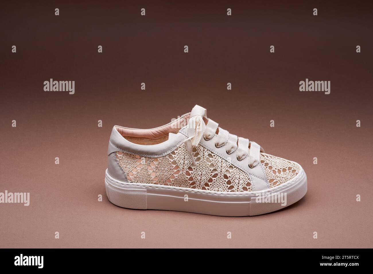 Stylish beige knitted design sneaker with a white thick rubber sole on ...
