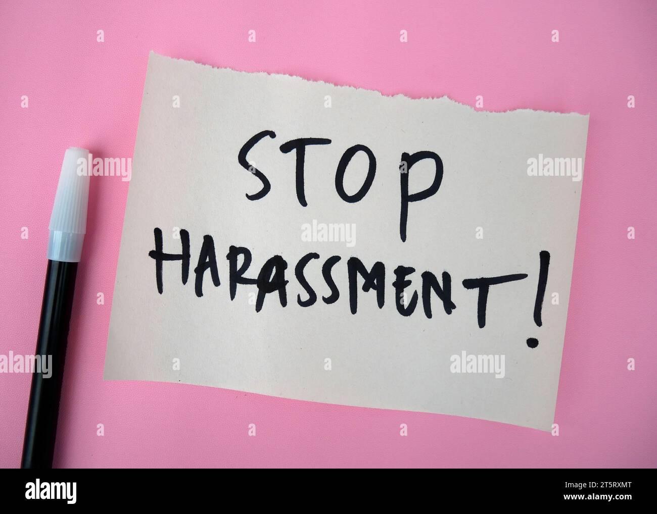 White paper with the text message stop harassment in the office written ...