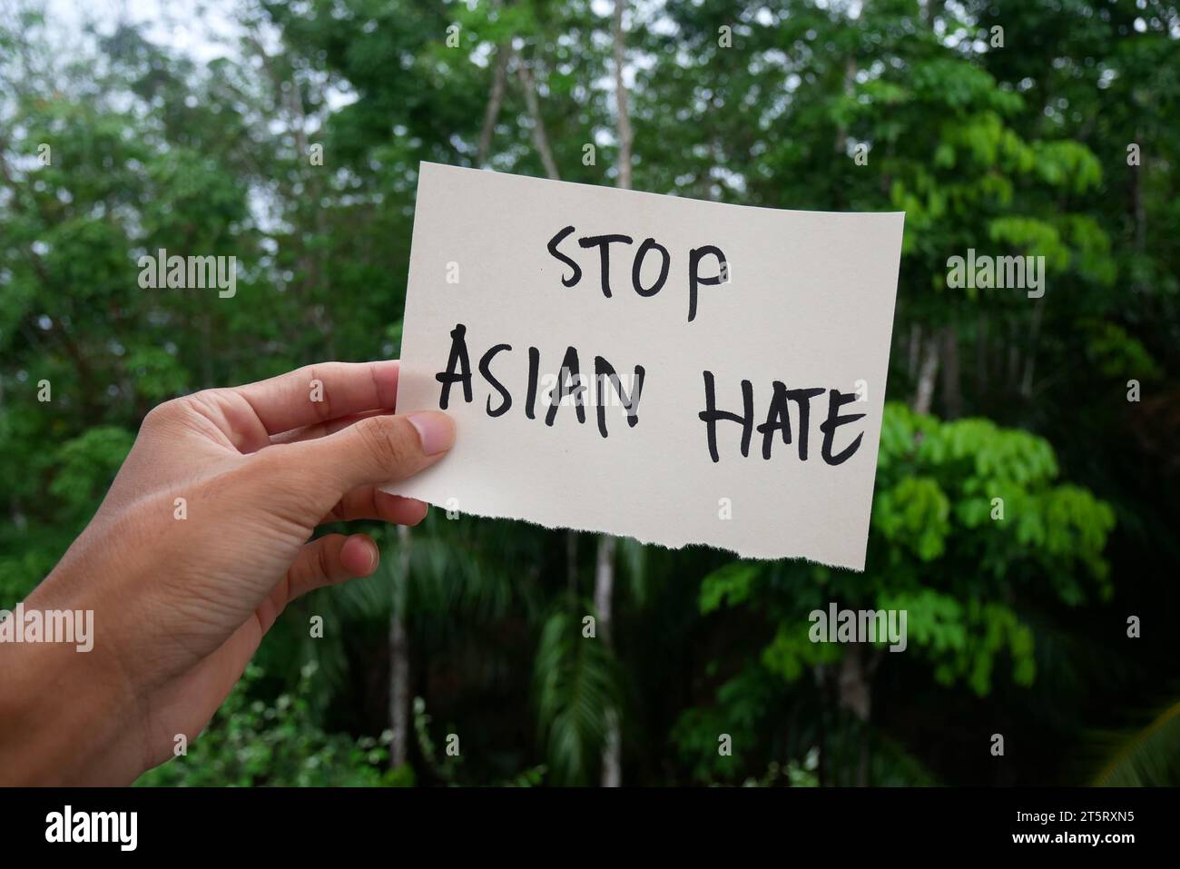 Paper with English words 'STOP ASIAN HATE' with pink heart in gray ...