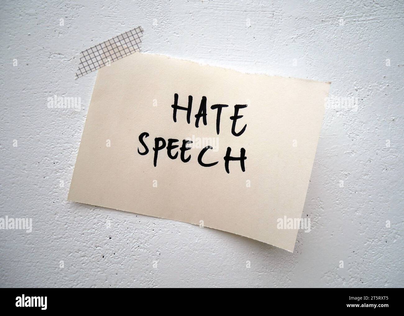 White paper with text hate speech stands on paper speech, political ...
