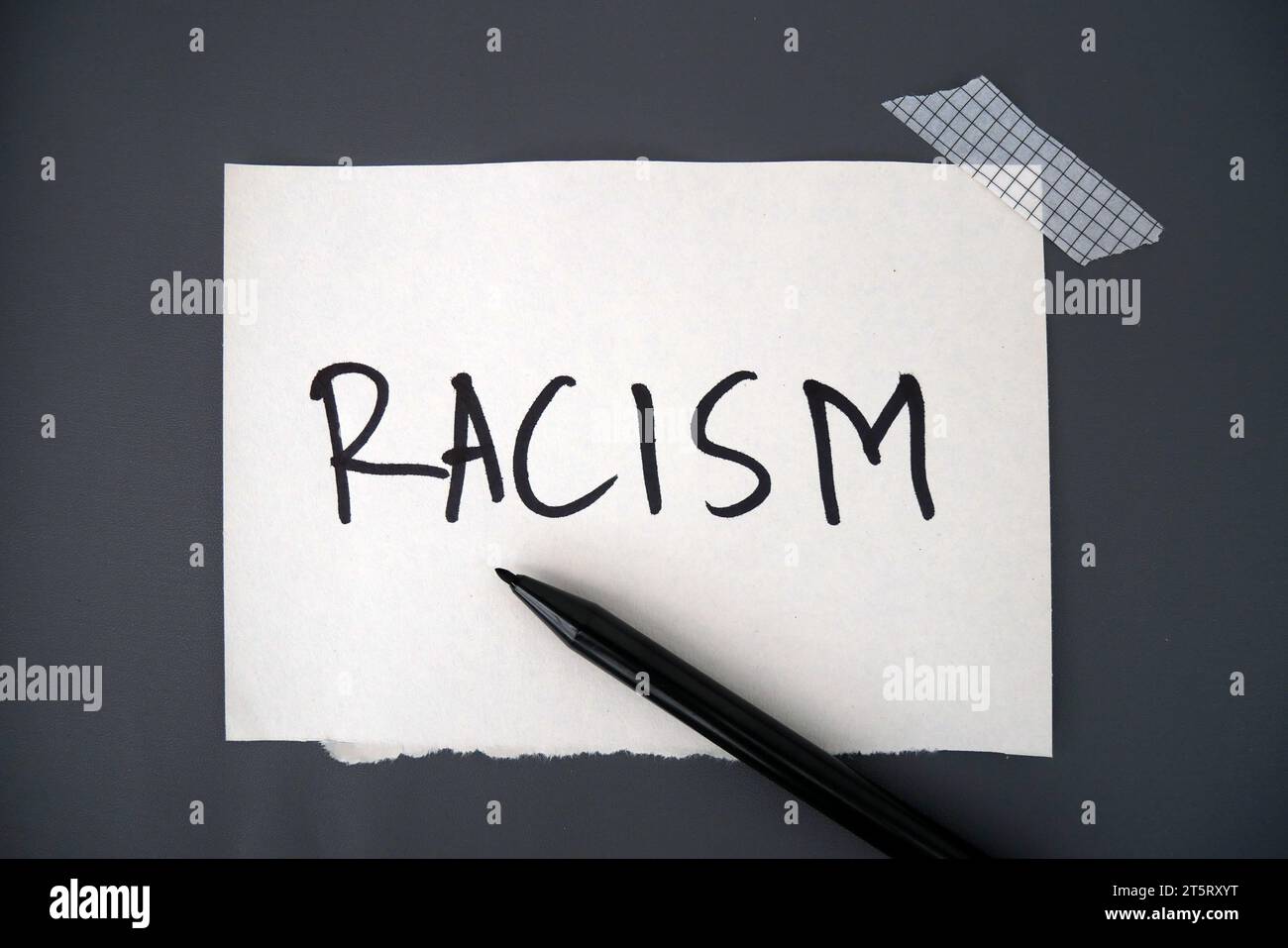 White paper with racism text in solative on gray background. paper, pen ...