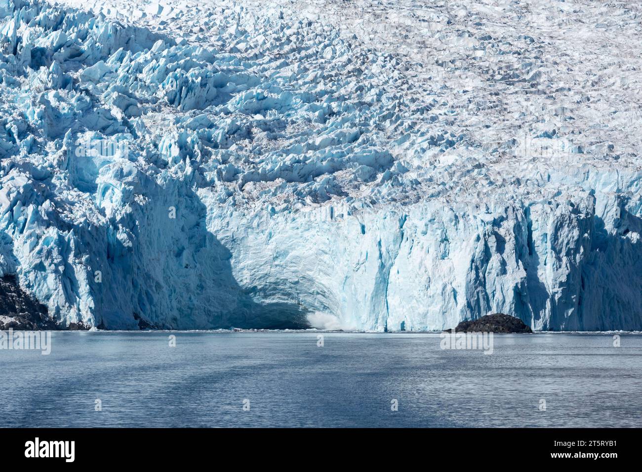 Blue ice of the Aialik Glacier meets the ocean waters of the Gulf of ...