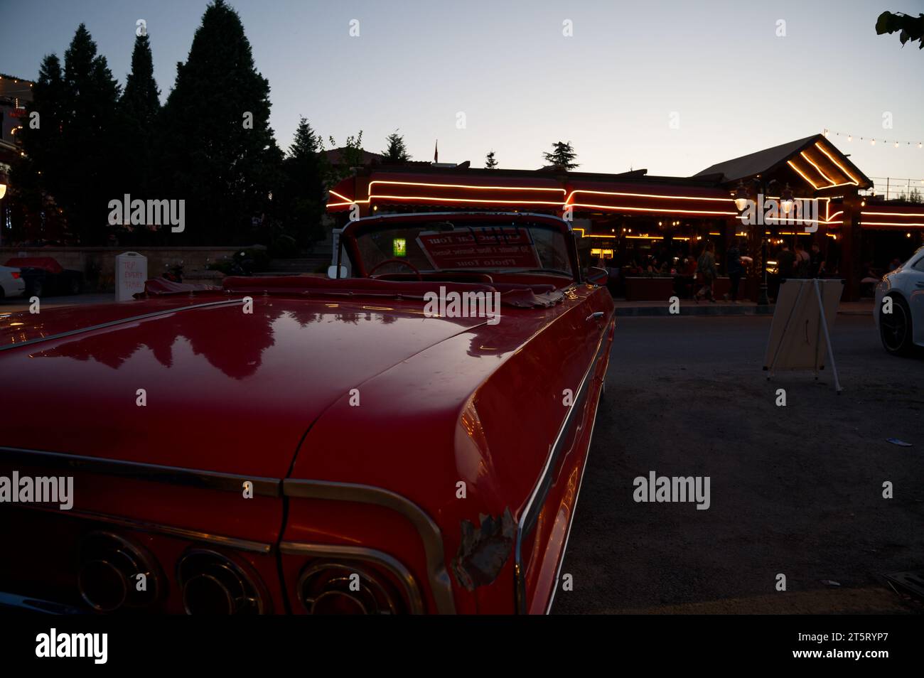 late afternoon glow on a classic red vintage car, rented for nostalgic ...