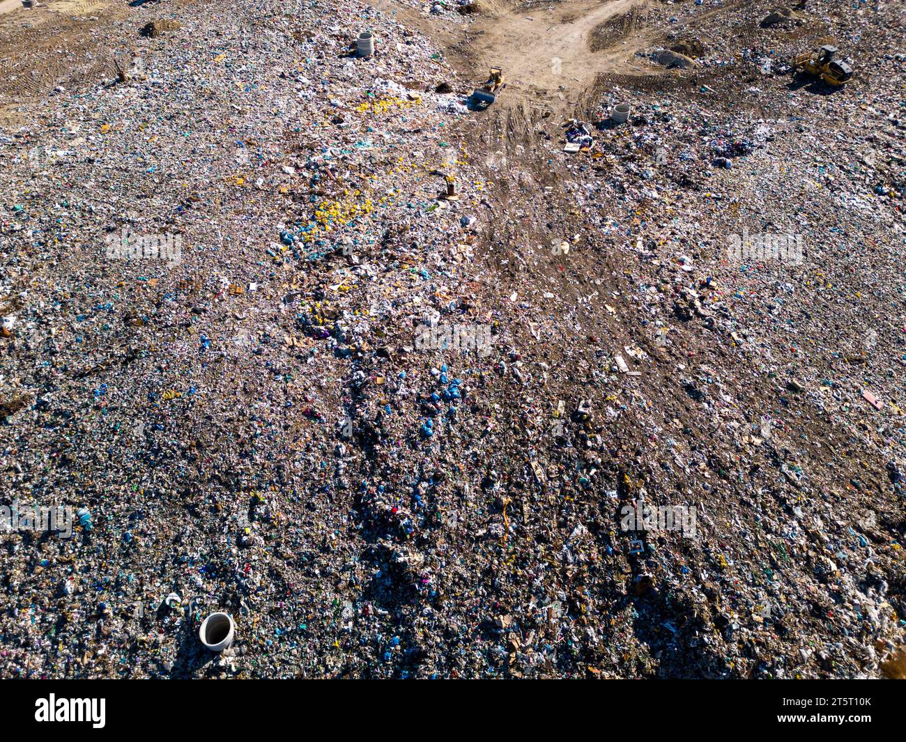 Aerial view of a vast landfill, where bulldozers are working and trucks ...