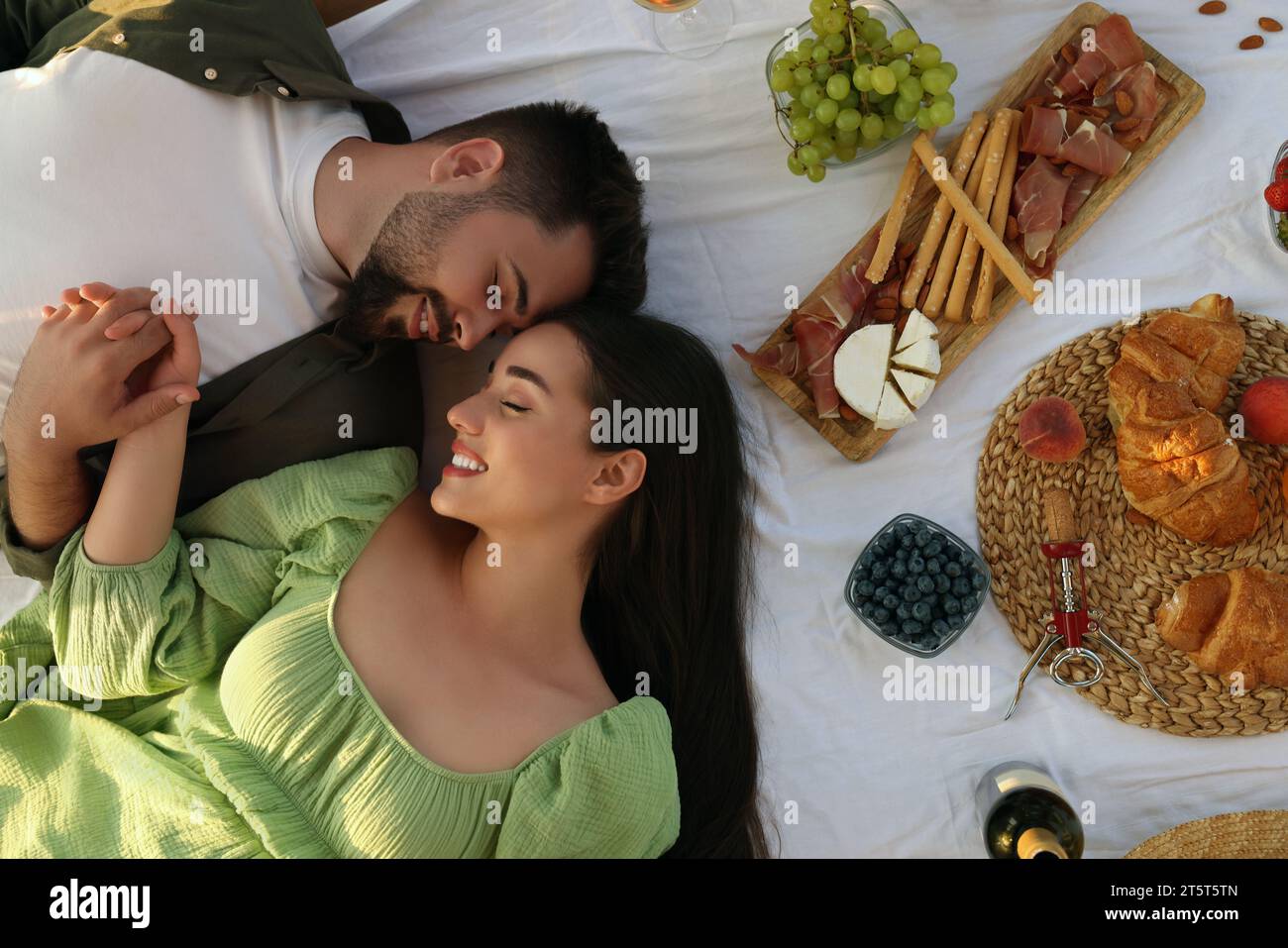 Romantic date. Beautiful couple resting on picnic blanket, top view ...