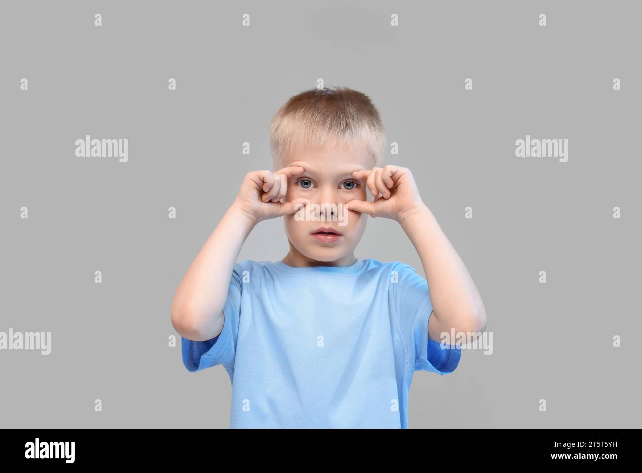 Sleepy boy on light grey background. Insomnia problem Stock Photo - Alamy