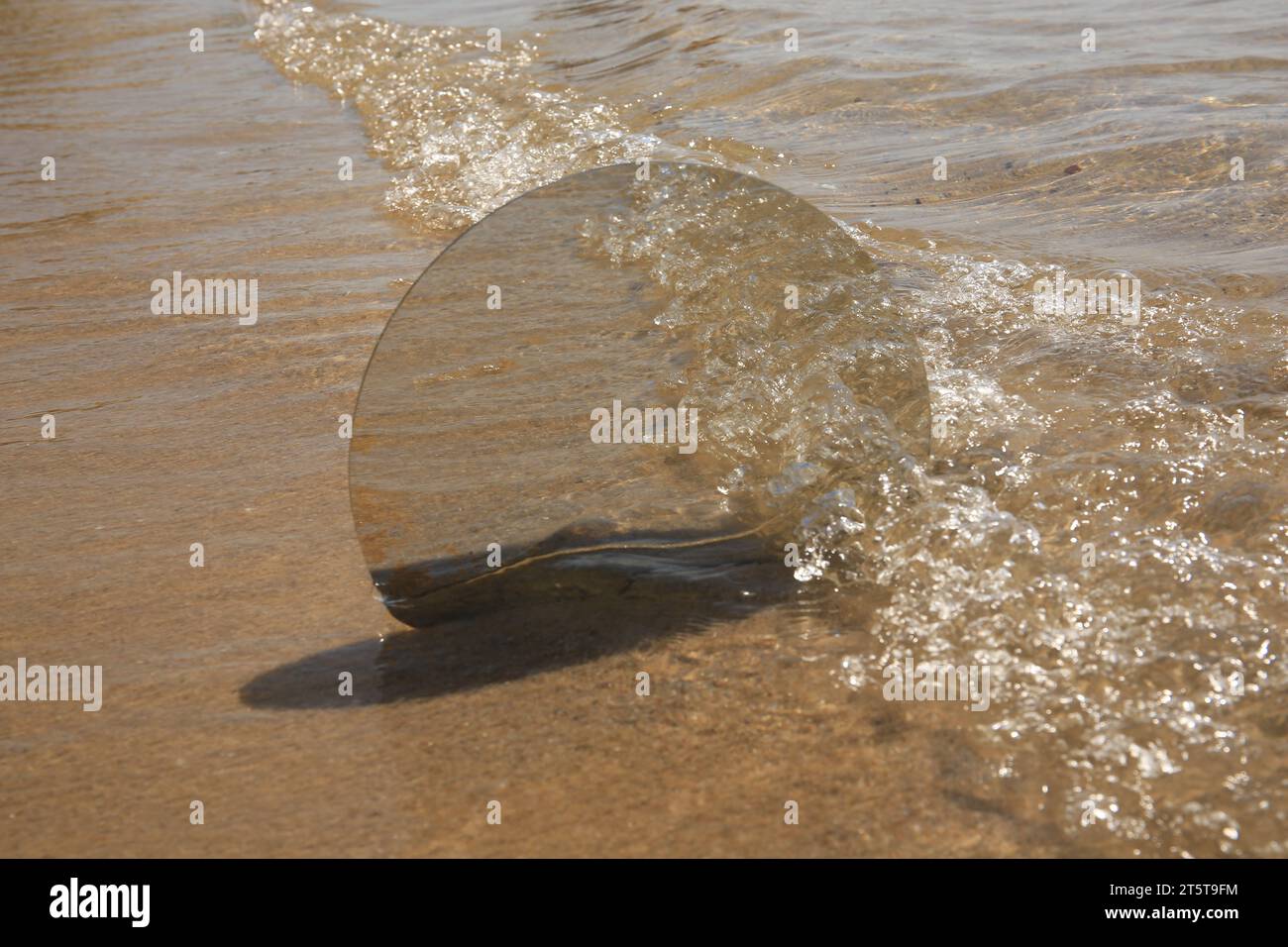 Round mirror reflecting sea on sandy beach Stock Photo - Alamy