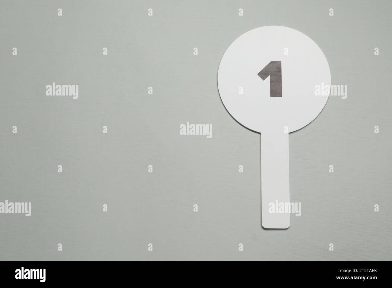 Auction paddle with number 1 on light grey background, top view. Space ...