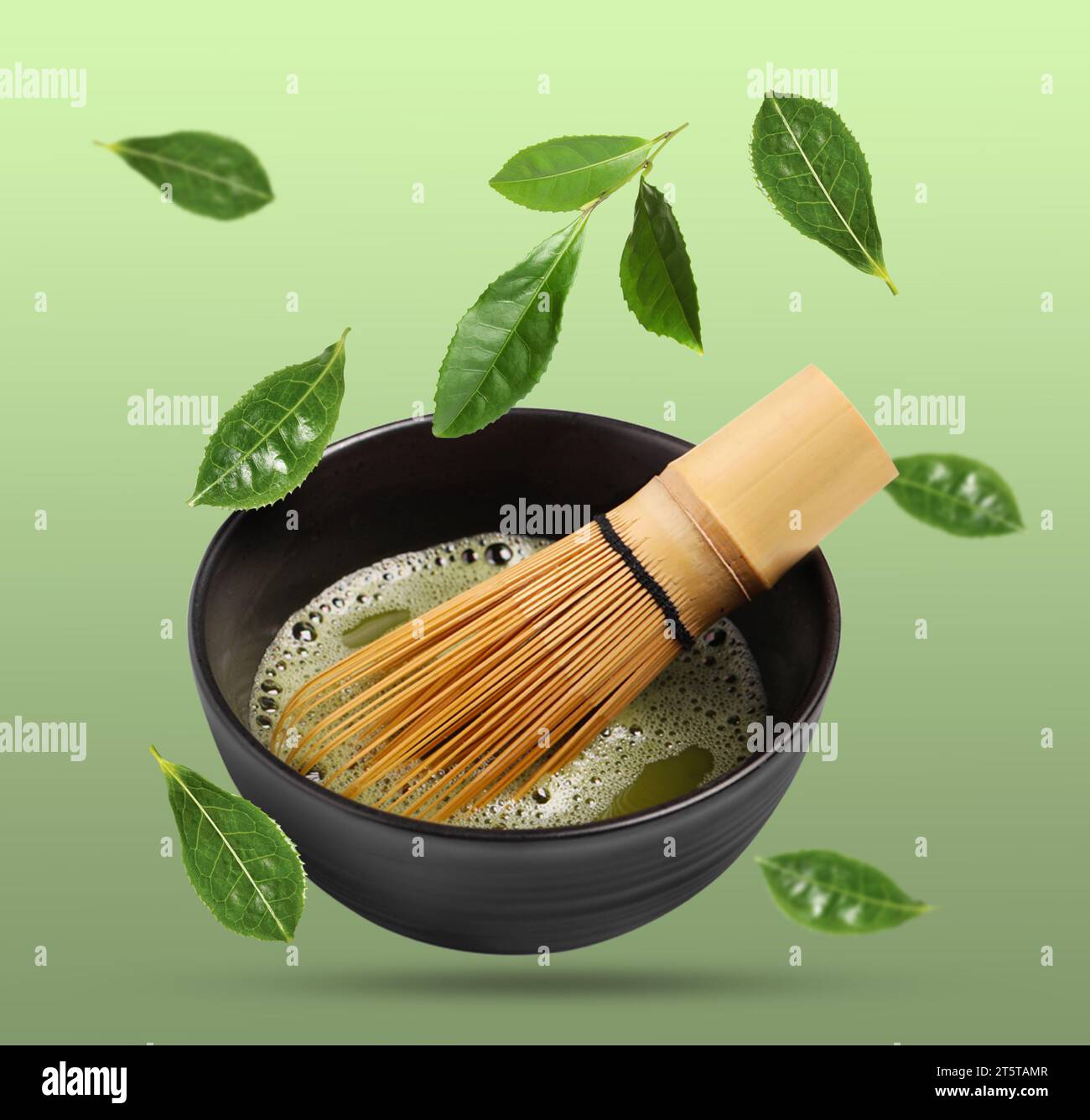 Tasty matcha tea in cup, whisk and leaves falling on light green ...