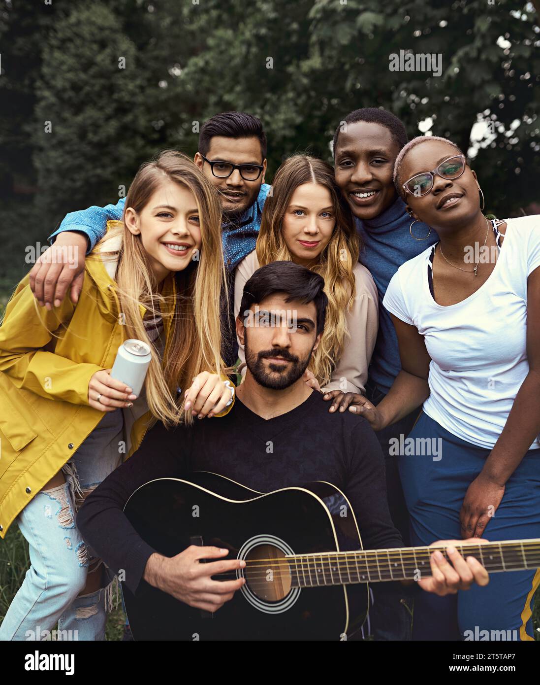 Diverse multinational group of six friends posing for camera while ...
