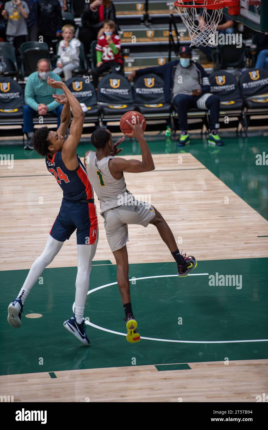 College basketball player finishing a contested layup during NCAA game ...
