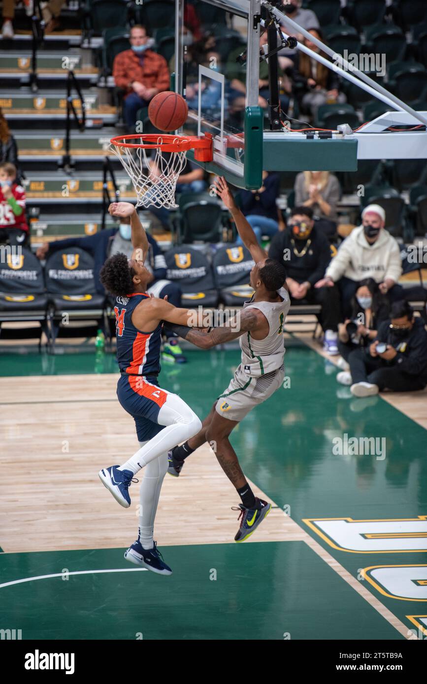 College basketball player finishing a contested layup during NCAA game ...