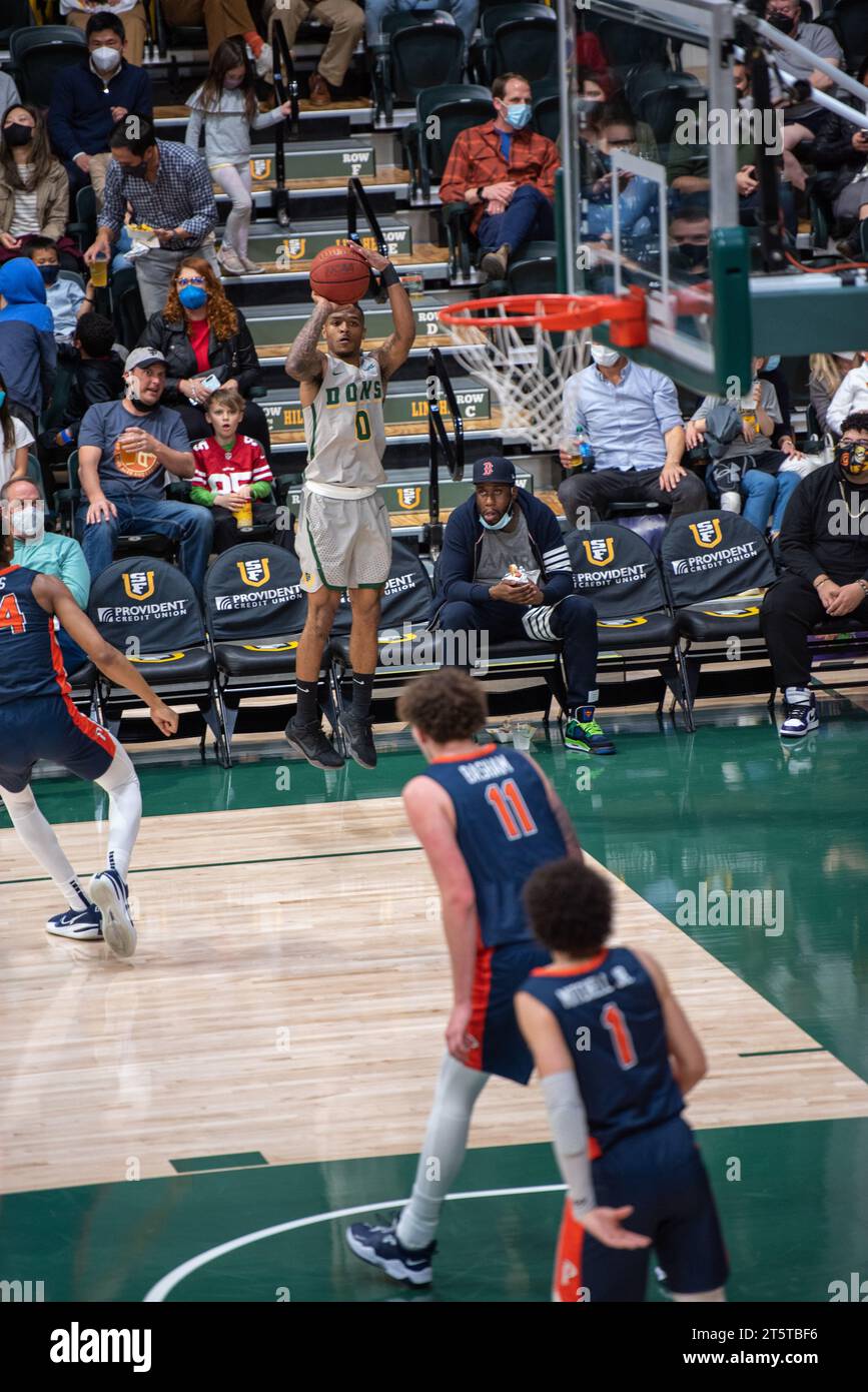 College basketball player rising for a jump shot during NCAA game ...