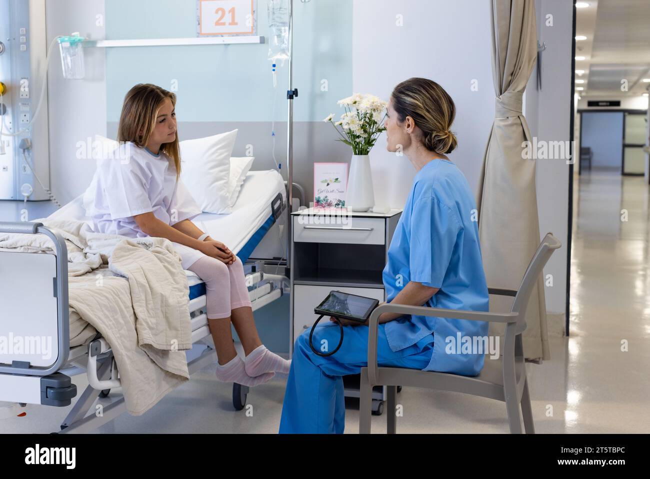 Caucasian female doctor with tablet and girl patient sitting in ...