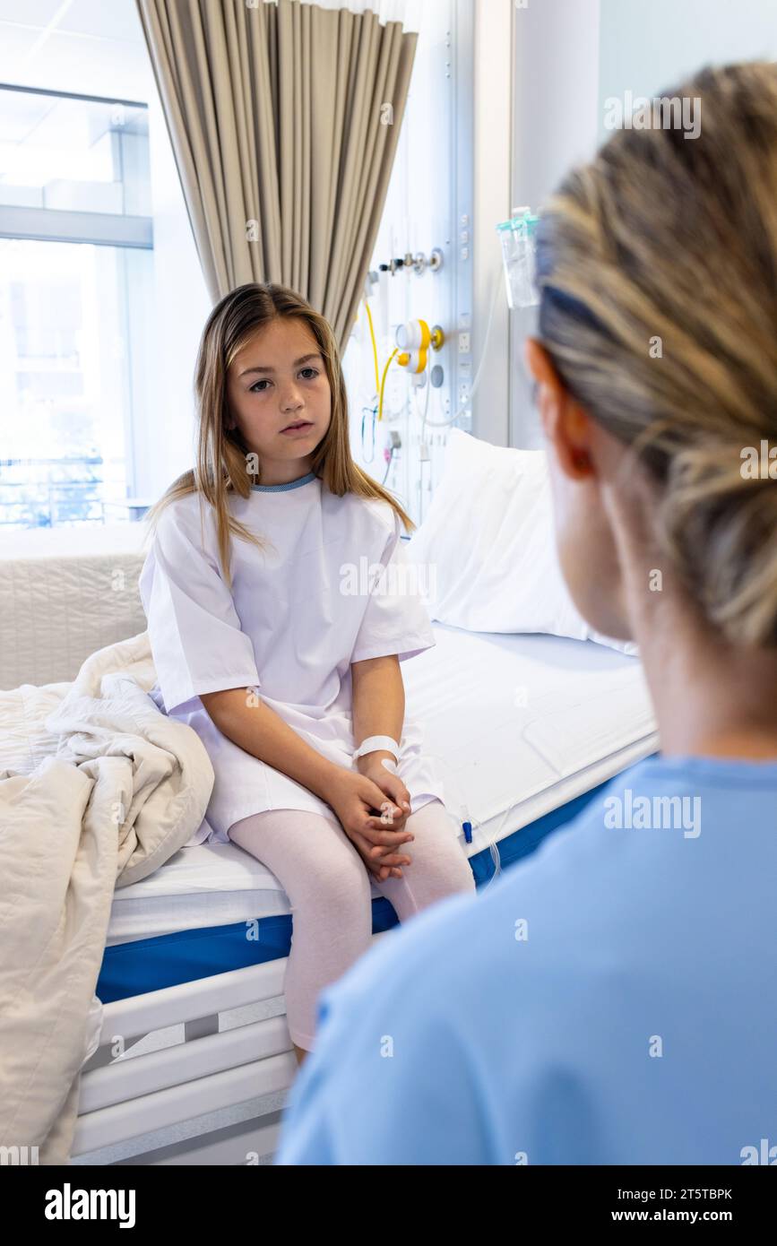Tired caucasian girl patient sitting on hospital beds talking with ...