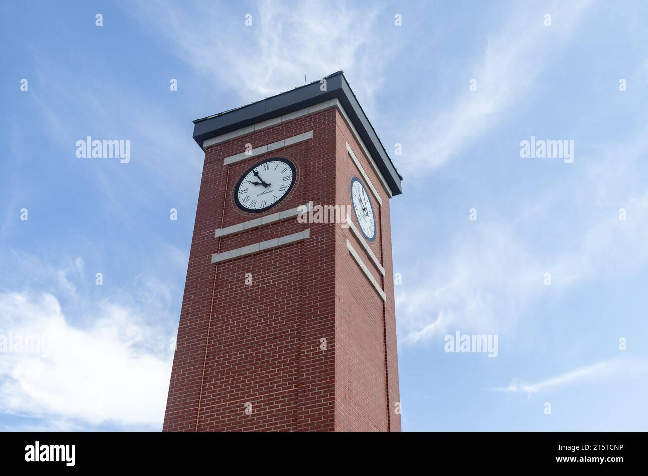 Red brick clock tower - blue sky background Stock Photo - Alamy