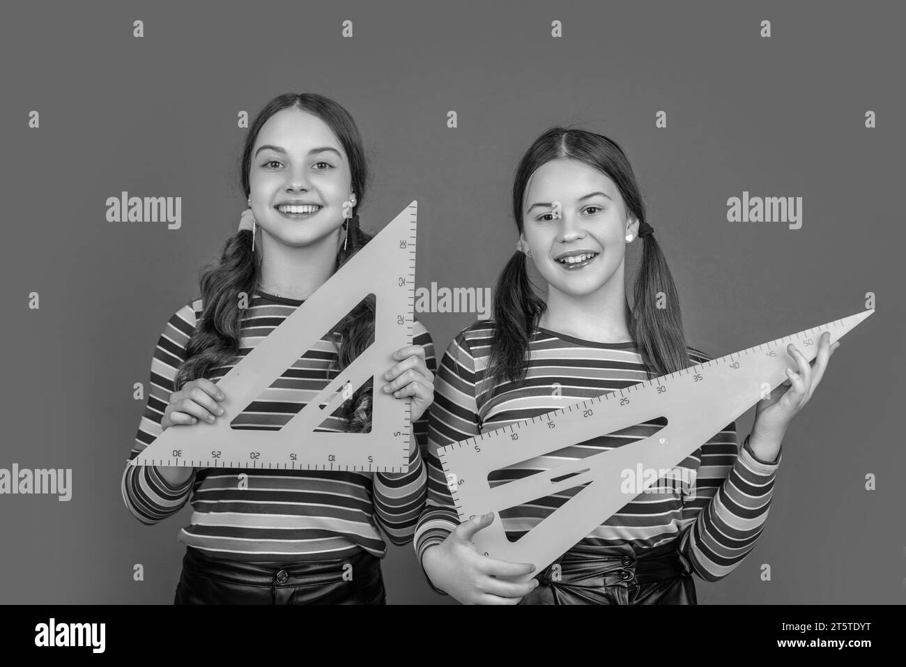 happy school girls hold math tool of triangle Stock Photo - Alamy