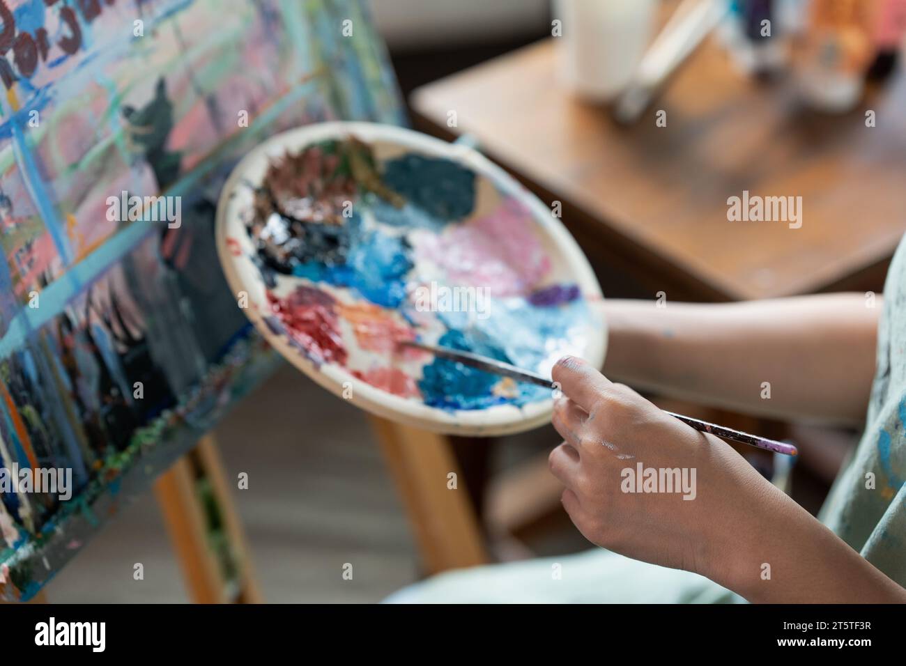 Female artist hold color palette and paintbrush for painting during ...