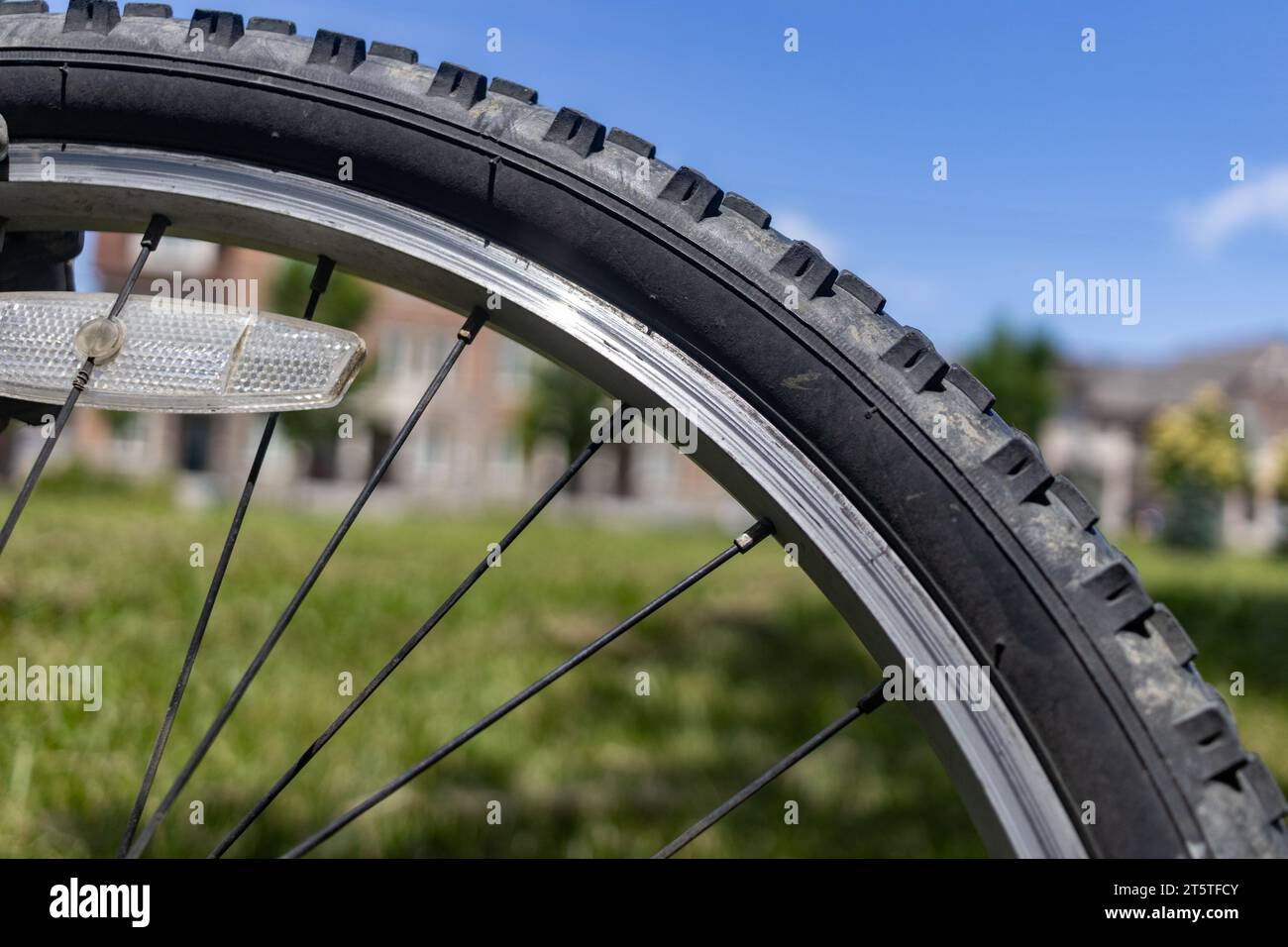 Bicycle wheel - close-up - grass - blue sky - suburban houses Stock ...