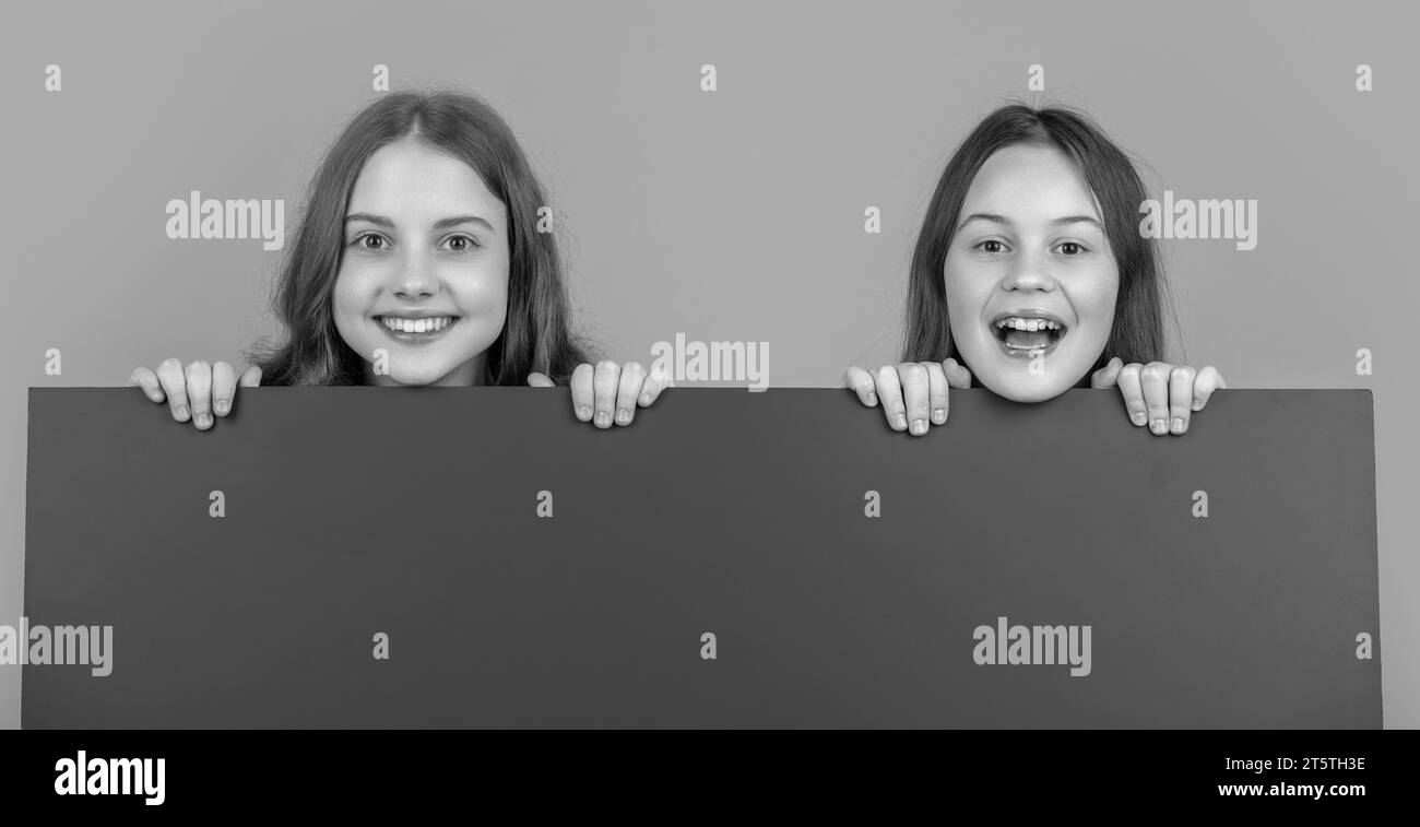 happy children behind blank blue paper with copy space for ...