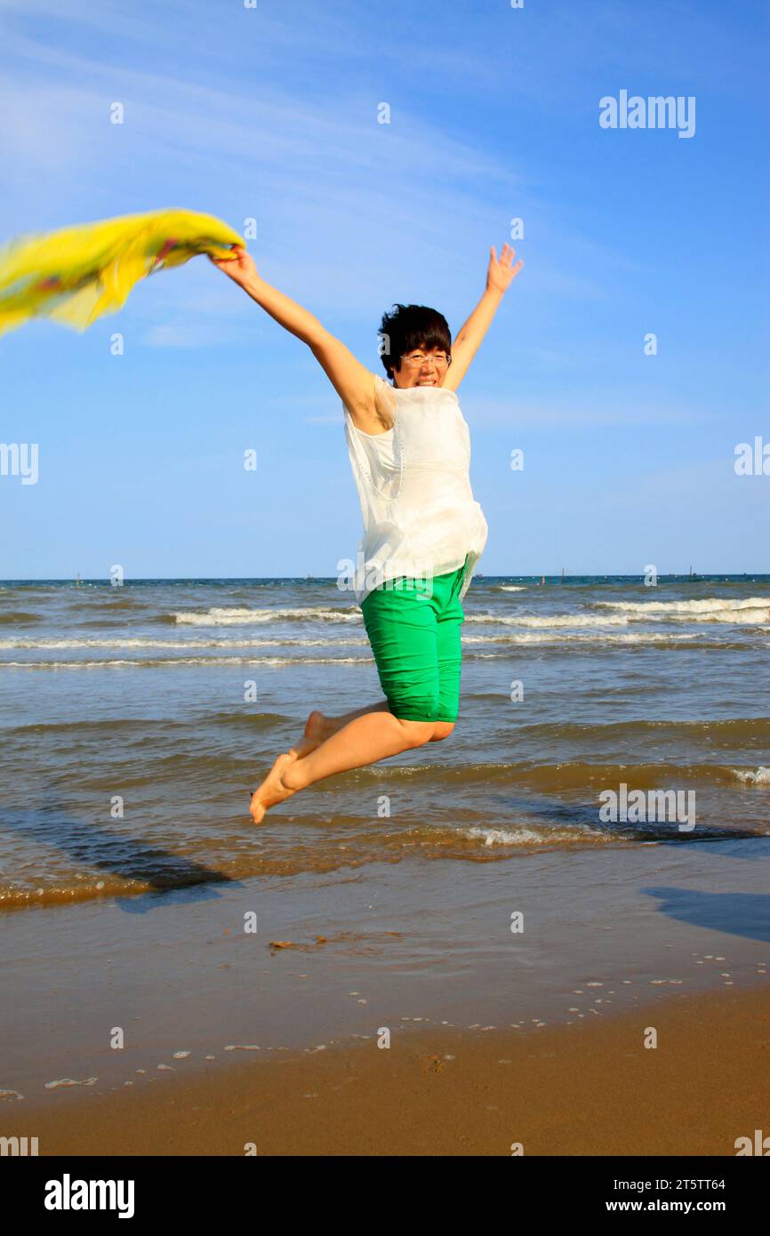 JINGTANG PORT - AUGUST 29: A lady jumping on the sea beach, on August ...
