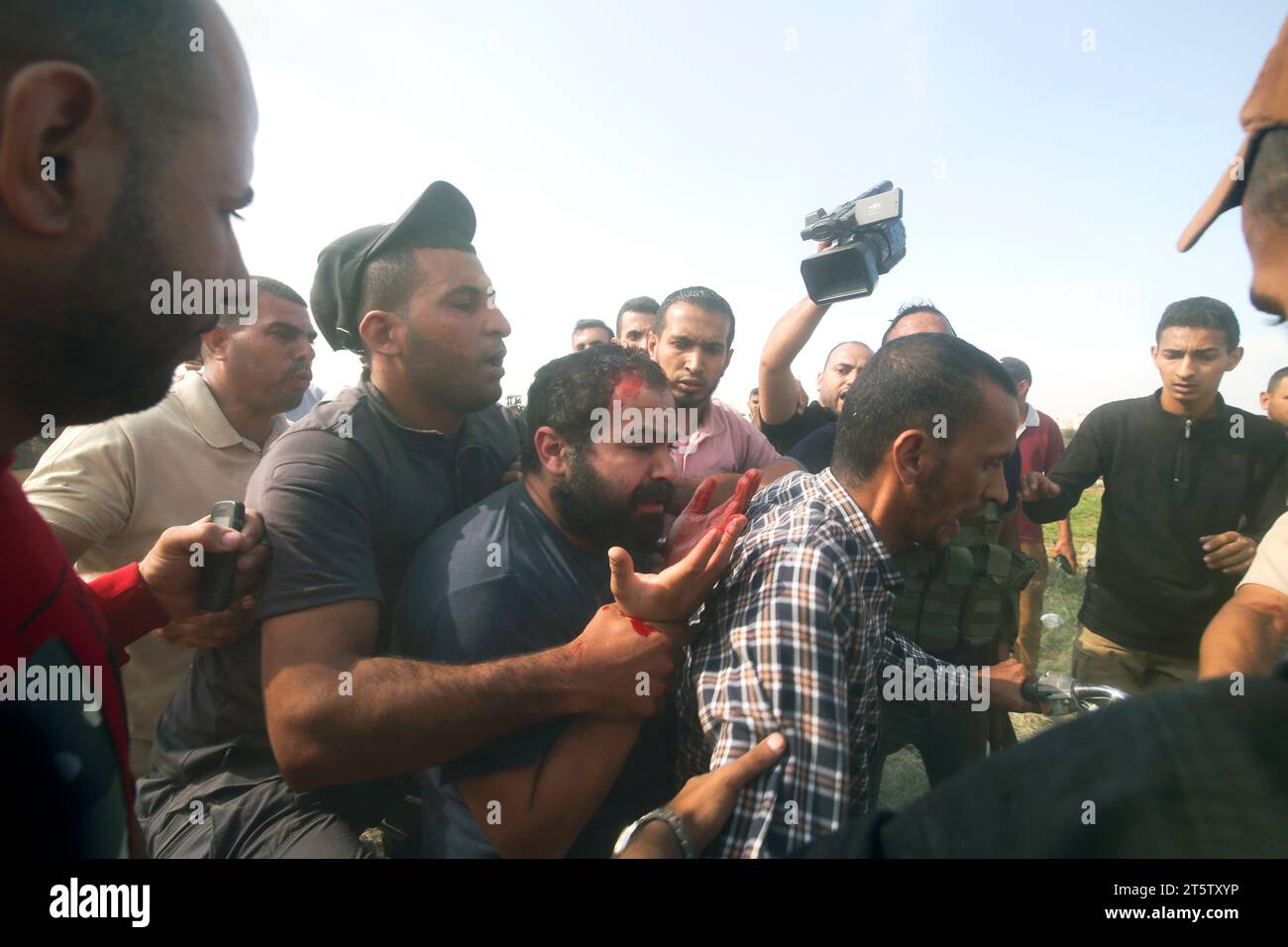 Palestinians transport a captured Israeli civilian, center, from ...