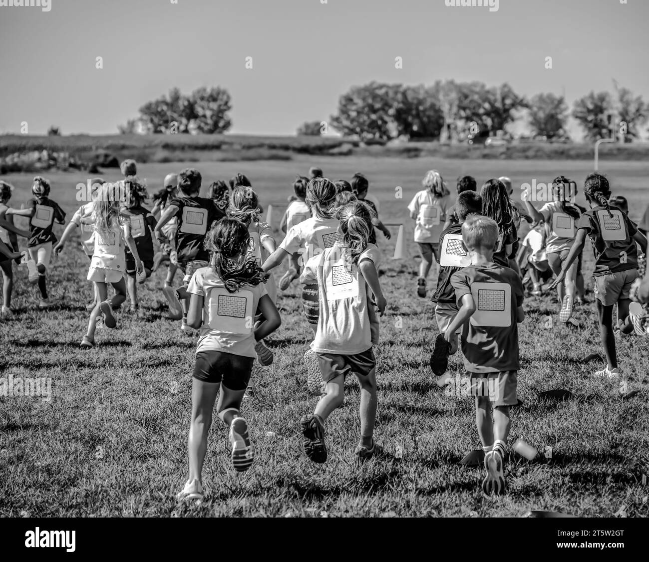Group of elementary school age children running forward during a ...