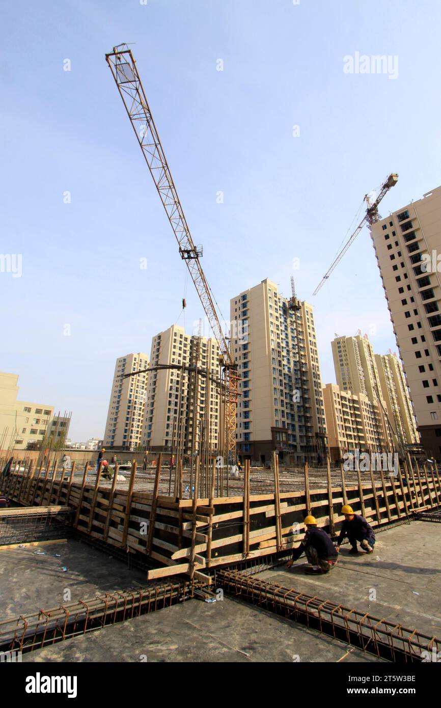 wood and steel tube scaffold in a construction site, busy scene of ...