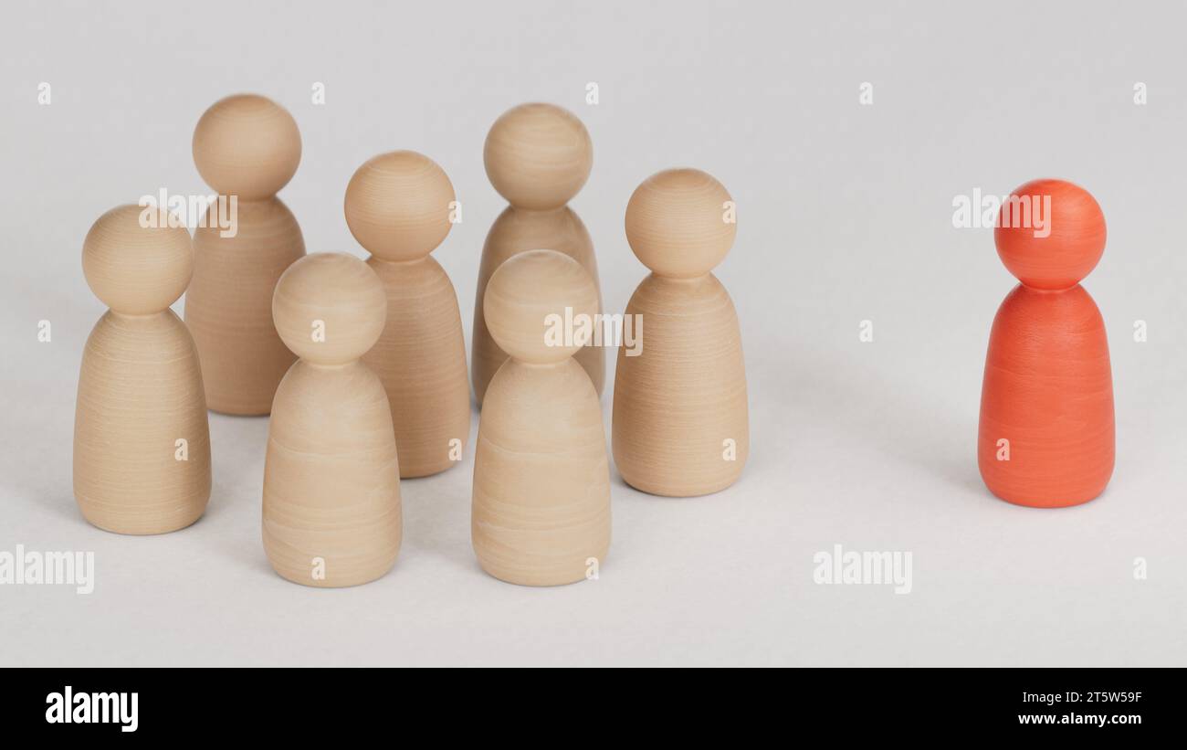 Concept of discrimination. Single red wooden peg standing away from a ...