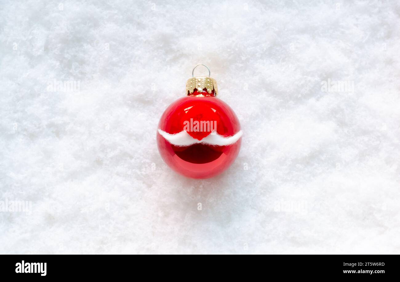 Red baubles set as Santa Claus face put on white snow flakes background ...