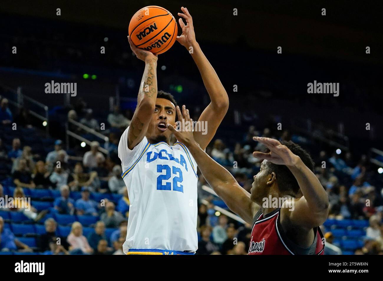 UCLA forward Devin Williams, left, shoots as St. Francis forward Gestin ...
