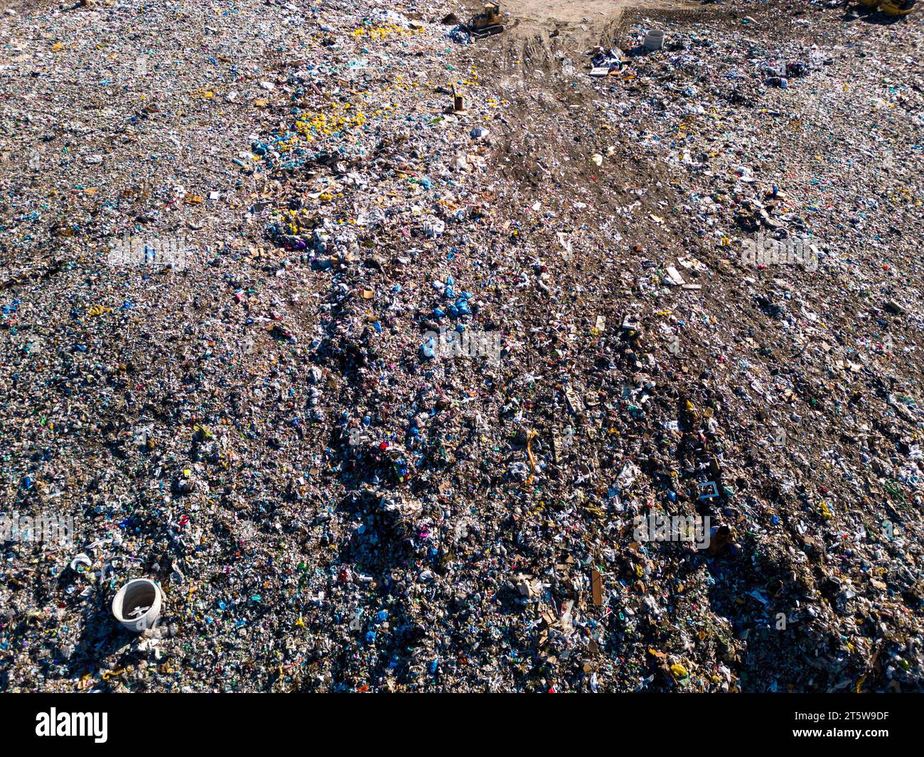 Aerial view of a vast landfill, where bulldozers are working and trucks ...