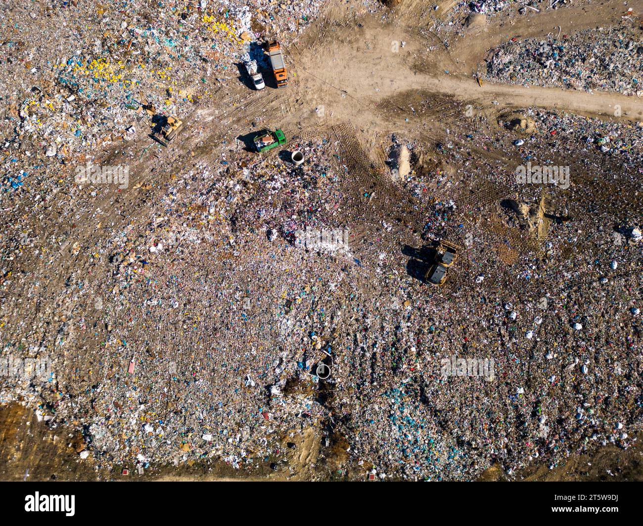 Aerial view of a vast landfill, where bulldozers are working and trucks ...