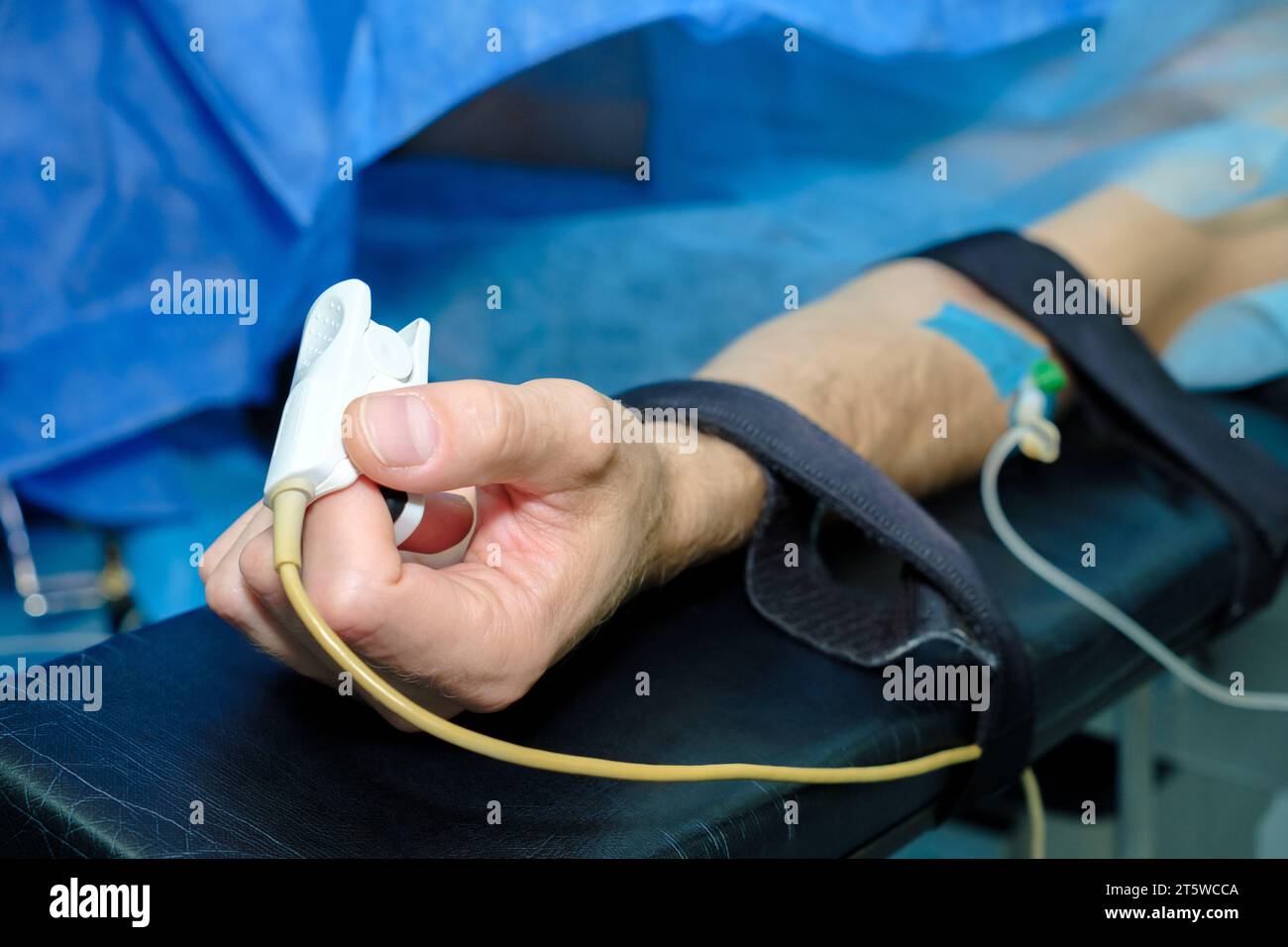 Selective focus on the pulse oximeter on the patient's finger ...