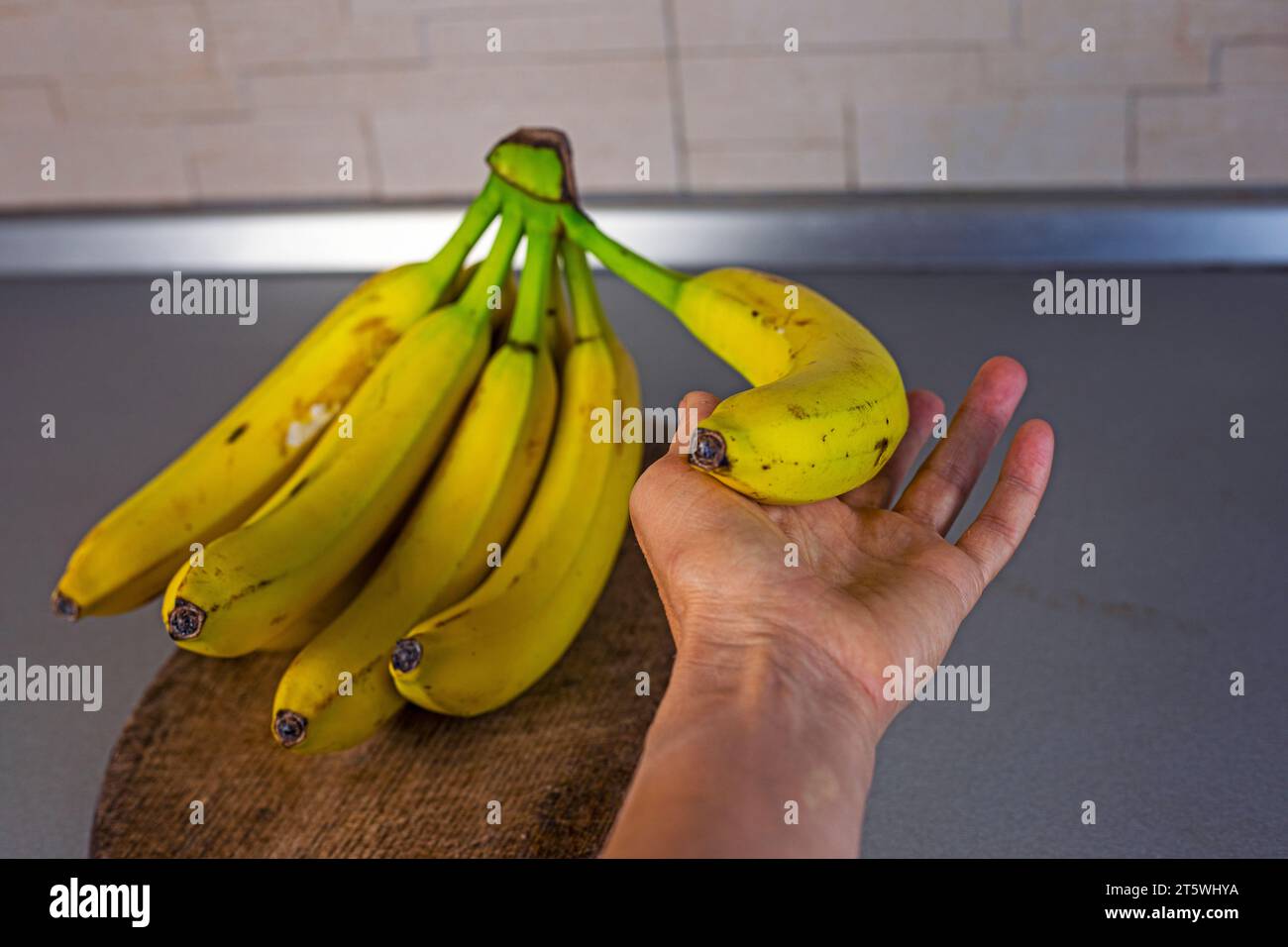 hold a bunch of bananas in the palm of your hand in the kitchen Stock ...