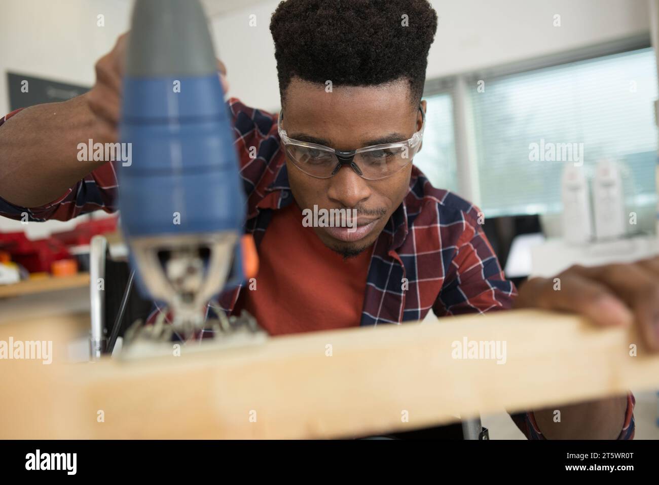 young man in wheelchair working on wood furniture Stock Photo - Alamy