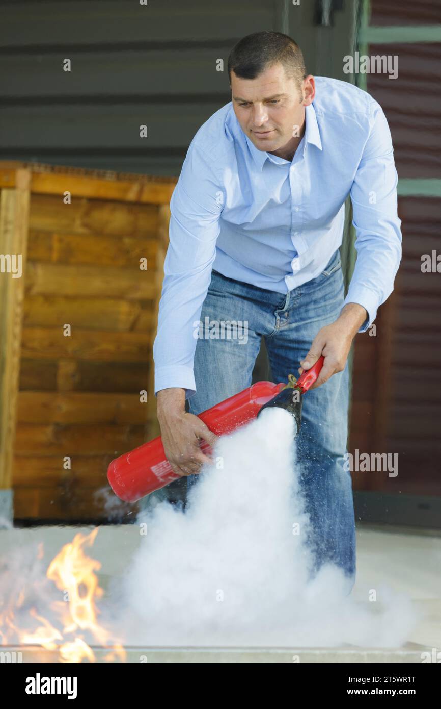 man extinguishing controlled fire during training exercise Stock Photo ...