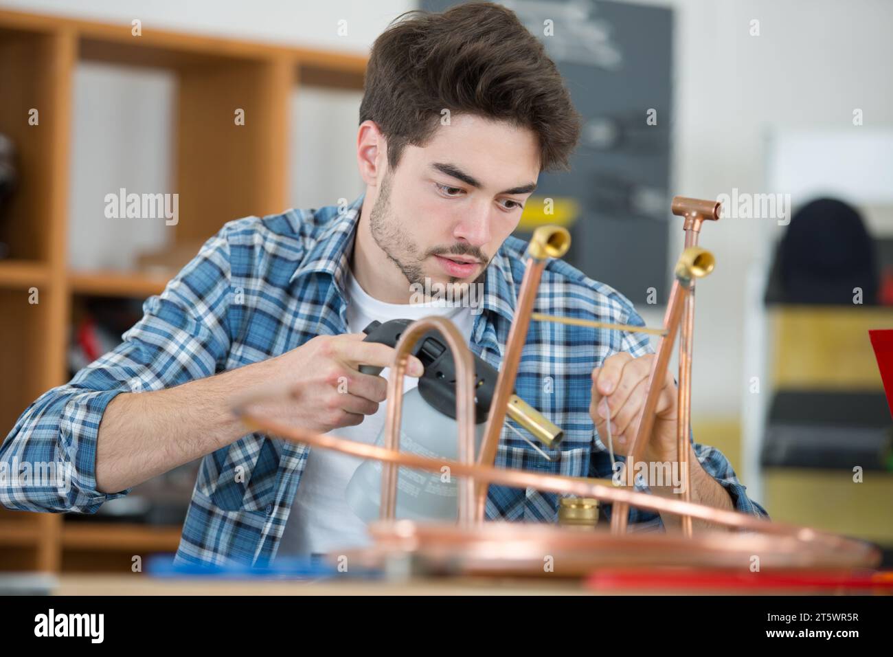 young worker heating copper pipe with gas torch Stock Photo - Alamy