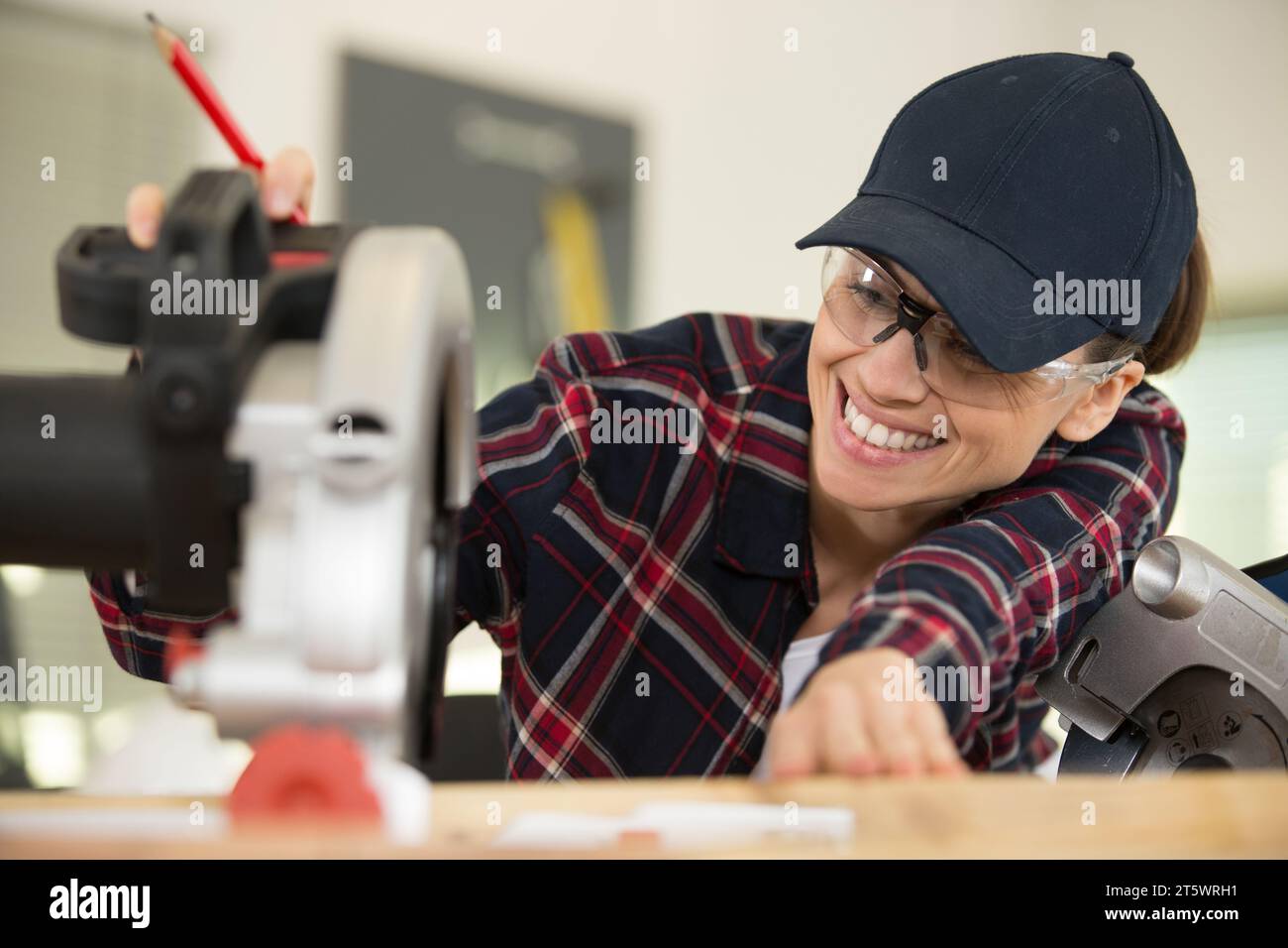 laughing woman using a circular saw Stock Photo - Alamy